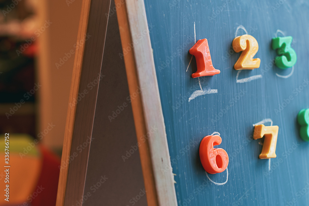 Learning numbers on a blackboard with colorful magnets and handwriting ...
