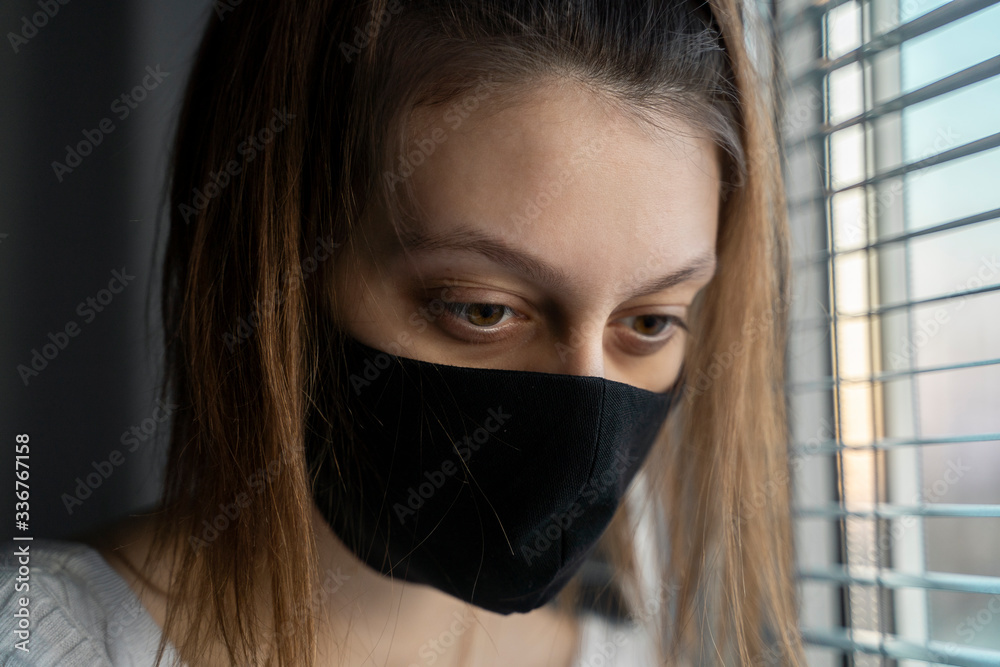 The girl in the black medical mask looks lowered her head down. Hair ...