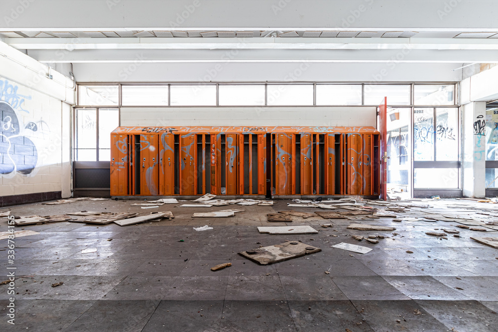 Row of bright orange lockers inside a decaying abandoned school with ...