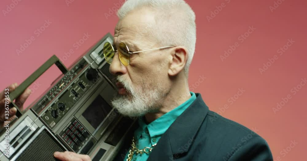 Close up of Caucasian old gray-haired man holding big retro tape ...