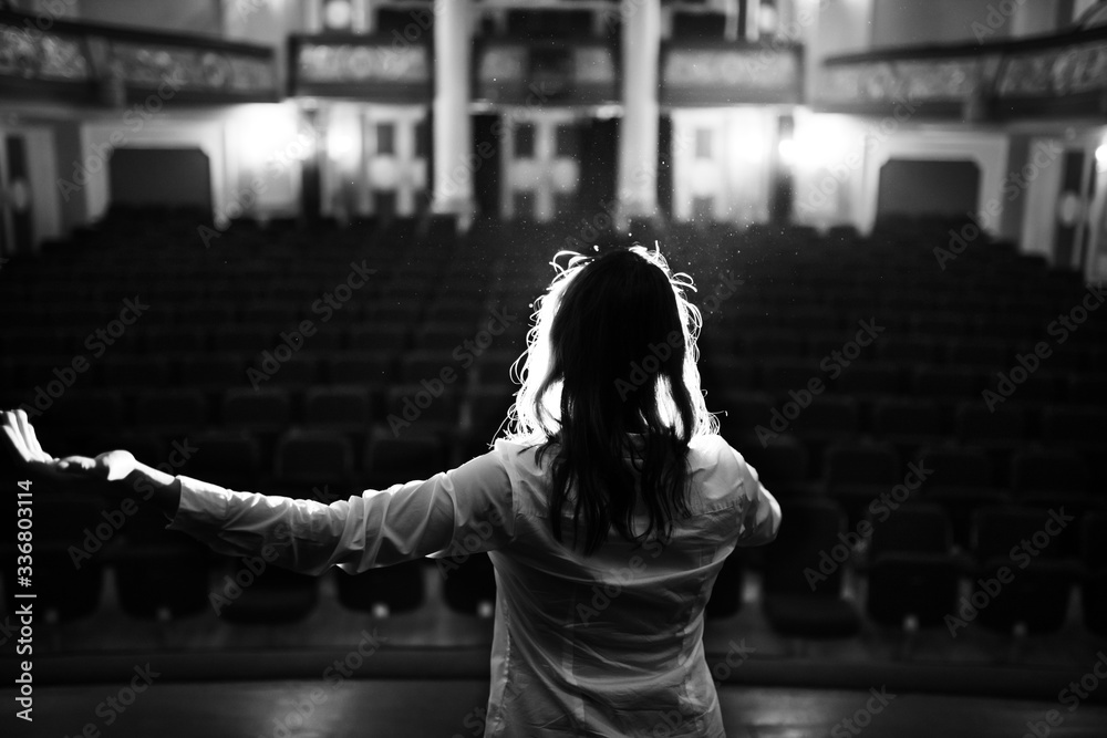 Entertainer performing on a stage in a empty theater,concert hall ...