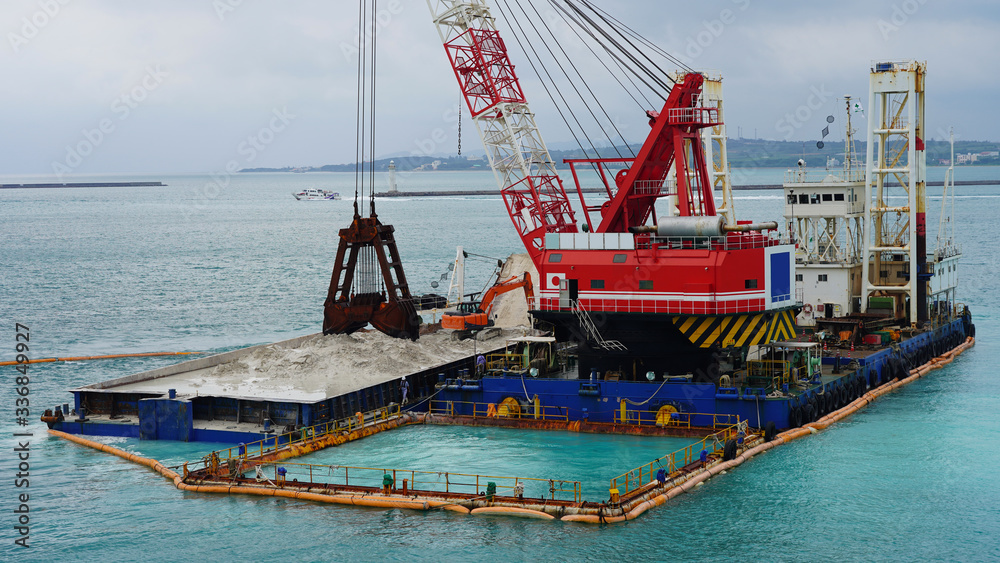 Floating crane platform with a huge bucket extracts sand from the ...