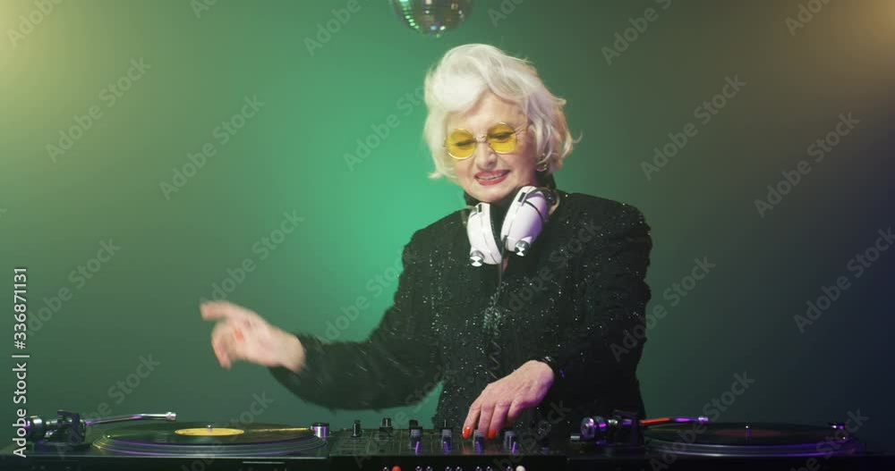 Stylish vintage grey-haired lady dancing while playing disco. Retro ...