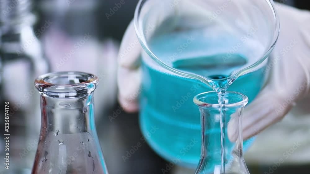 Stockvideon scientist hand holding a medical dropper filled with blue ...