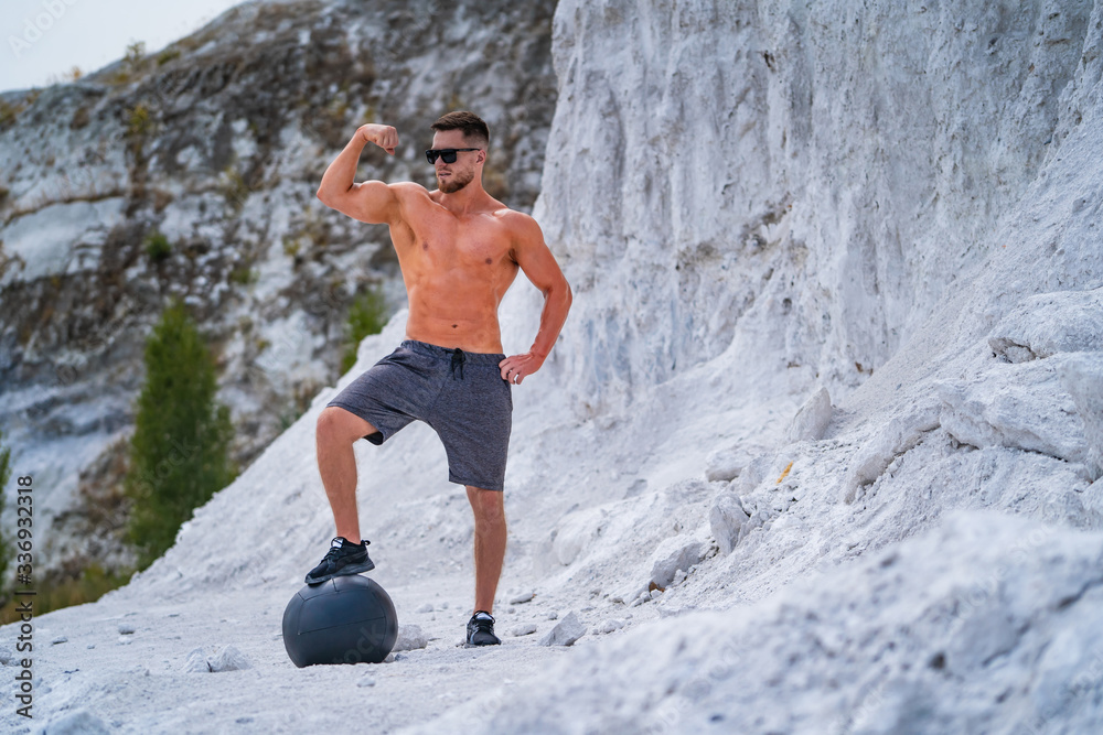 Strong bodybuilder with naked torso posing outdoor. Photoshoot in a ...