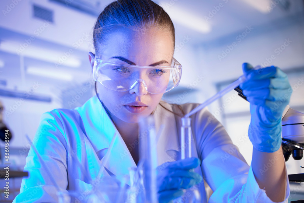 Science research concept. Young scientist during experiment and using ...