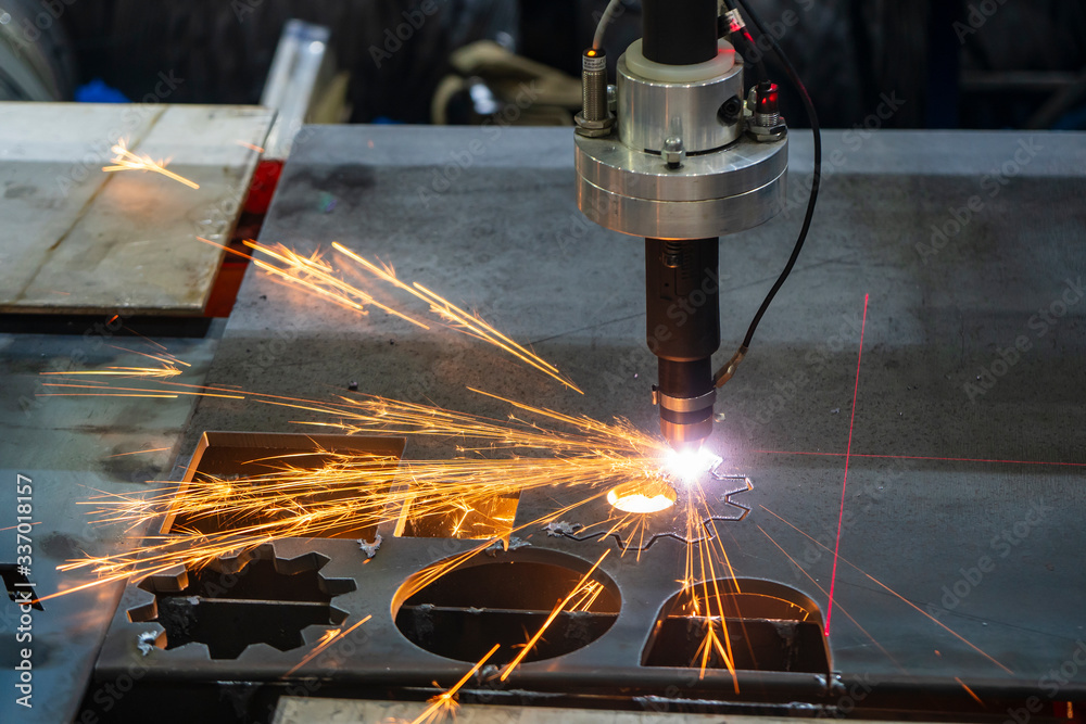 The laser cutting machine cutting the sheet metal plate with the ...