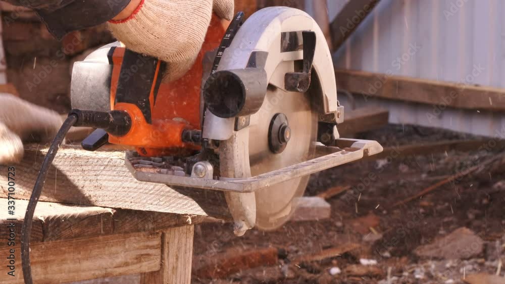The circular saw in process. The carpenter cuts the edges of a large ...