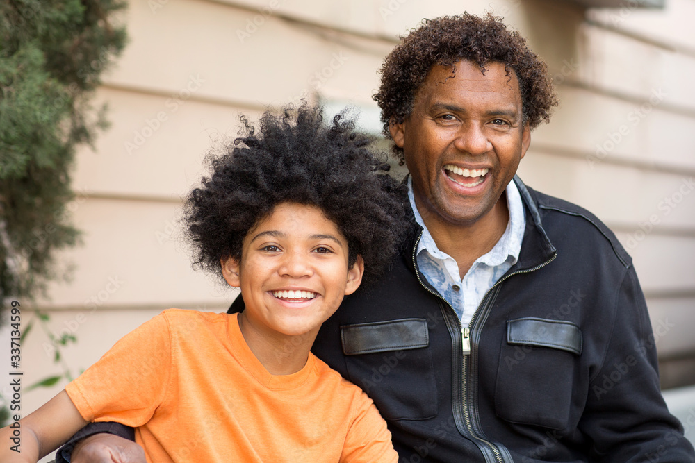 African American father hugging his son and smiling. Stock Photo ...