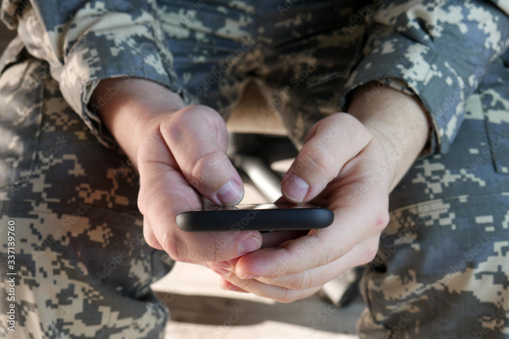 Military soldier using smartphone for texting. Army officer typing SMS ...