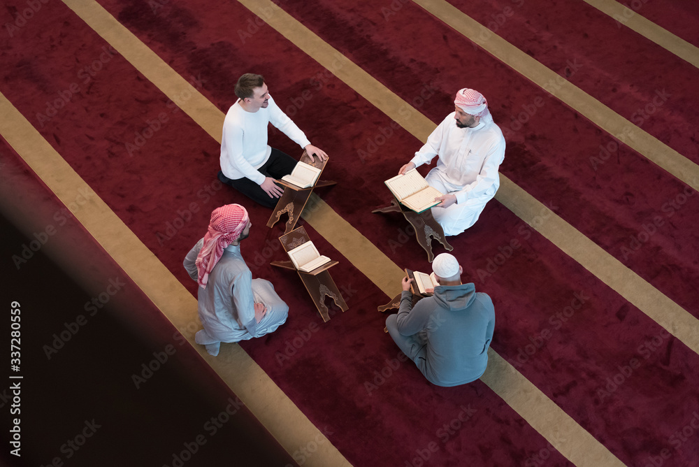 Group of muliethnic religious muslim young people praying and reading ...