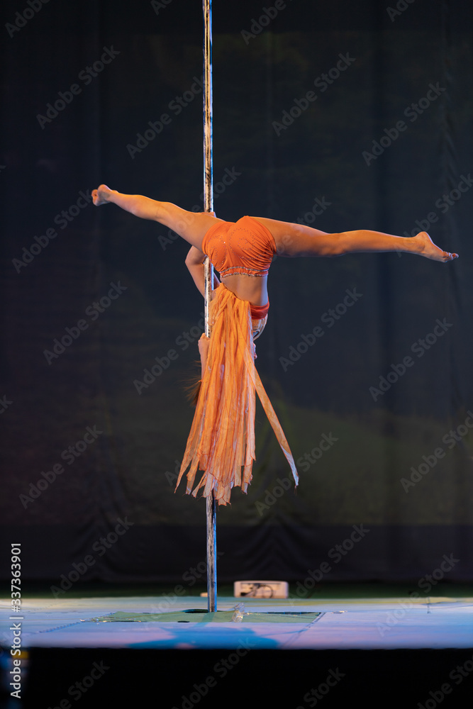 girl athlete gymnast shows an acrobatic performance on a pylon Stock ...