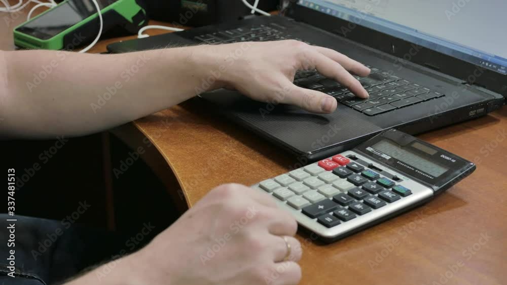 The businessman at home at the computer counts the numbers on the ...