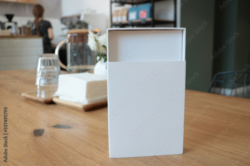 On the table is a white box suitable for mockup. Empty white background ...