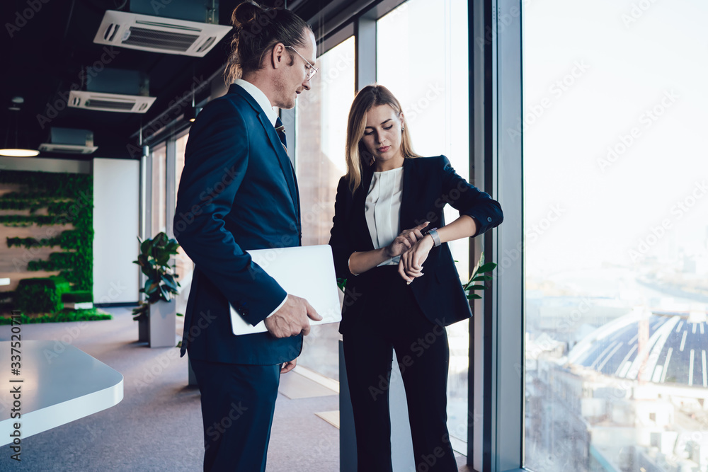 Confident female manager checking notification on smartwatch ...