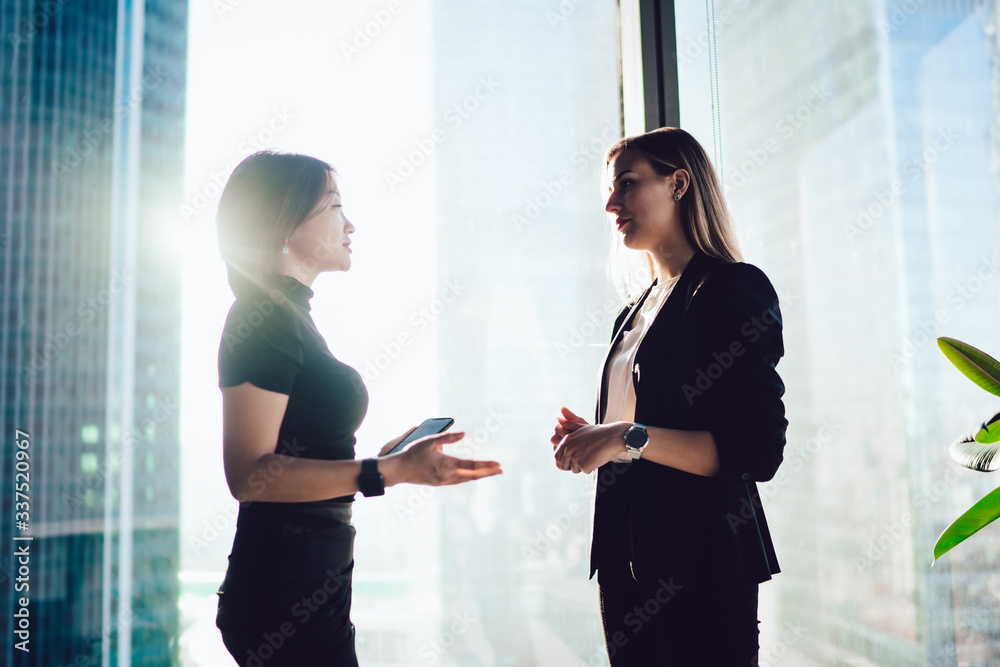 Diverse female managers in elegant wear discussing working issues ...