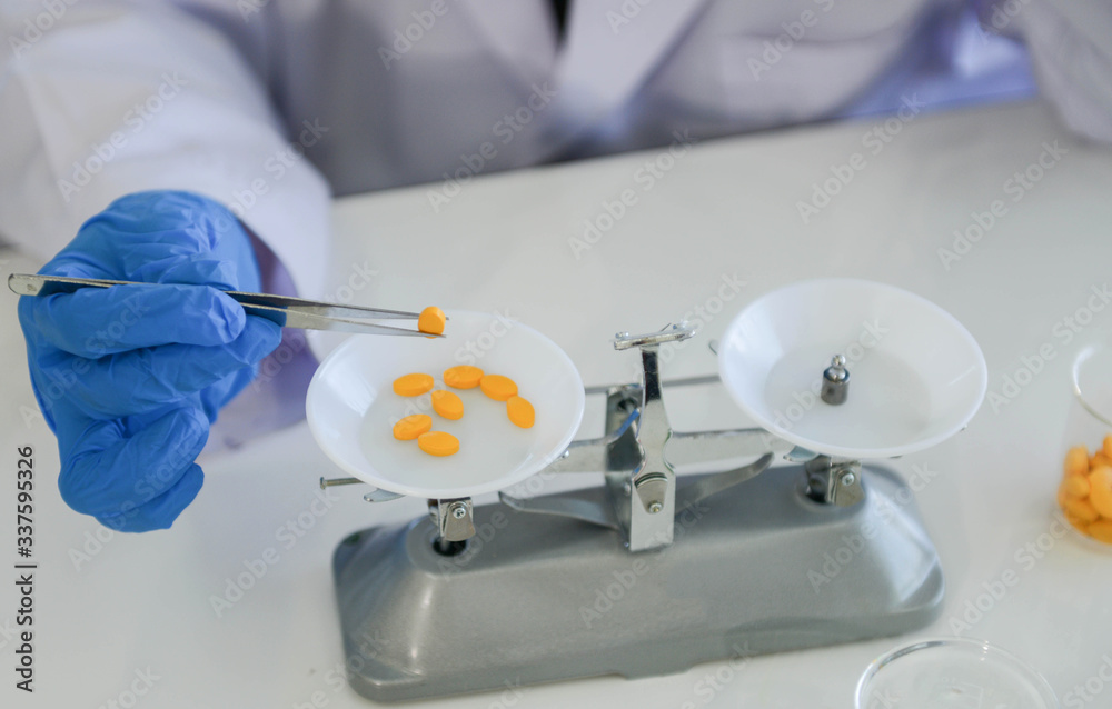 Pharmacists measure dosing using weighted scales Stock Photo | Adobe Stock