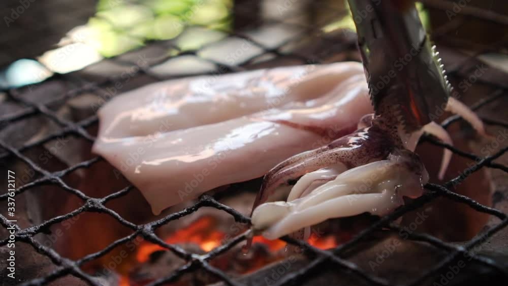 Sliced squid get grilling on a traditional stove. Thai seafood menu ...