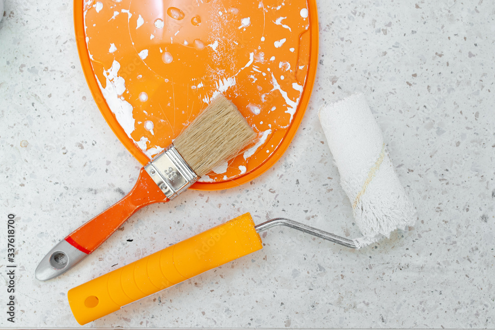 Paint roller with a brush paints the shelves and walls pours and flows ...
