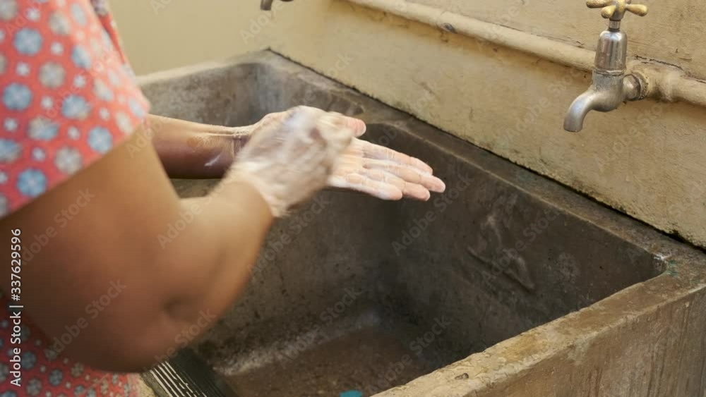Close up shot of black African woman washing her hands to prevent the ...