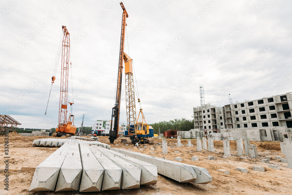 construction piles and pile driver during the construction of a multi ...