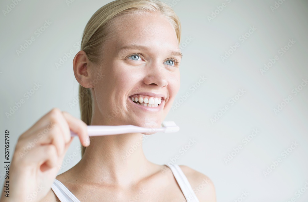 Beautiful blonde woman brushing her teeth. Attractive model brushing ...