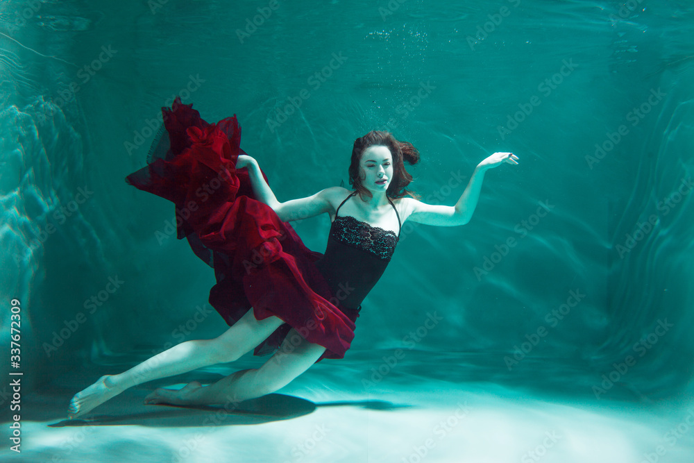 beautiful girl in a red dress swims under water. amazing Underwater ...