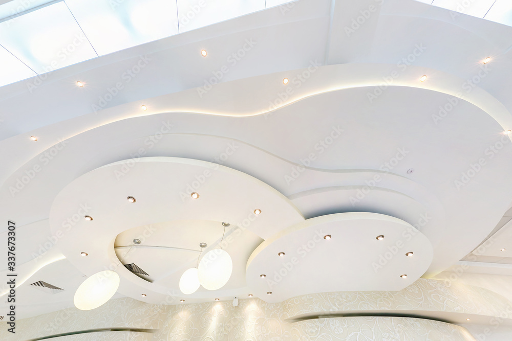 looking up on suspended ceiling with halogen spots lamps and drywall ...