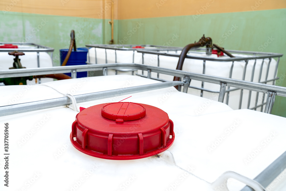 Overhead view inside of the factory. The large white tanks red lid of ...