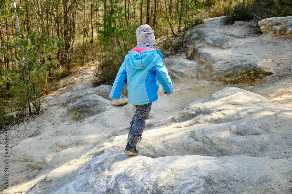 Rear view of 4 year old caucasian child girl in full length climbing up ...