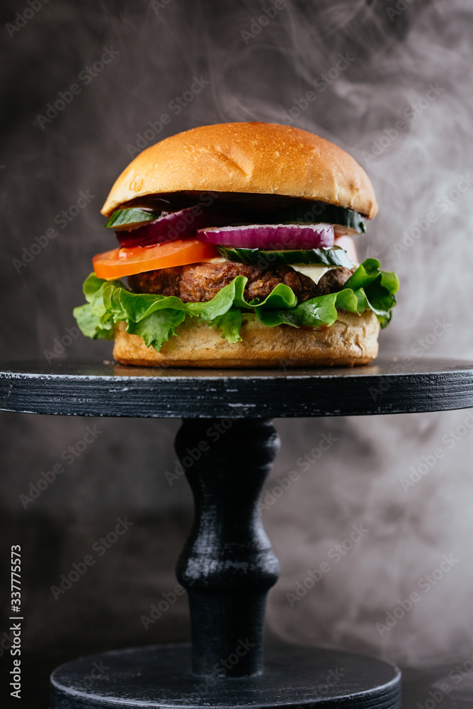 wooden black table with fresh grilled hamburger with french fries in ...