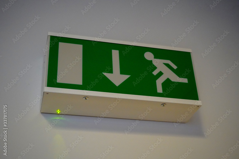 Emergency exit sign hanging on a wall Stock Photo | Adobe Stock