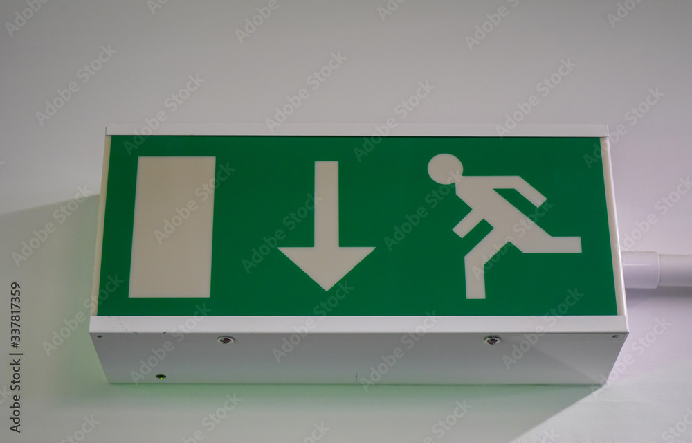 Emergency exit sign hanging on a wall Stock Photo | Adobe Stock