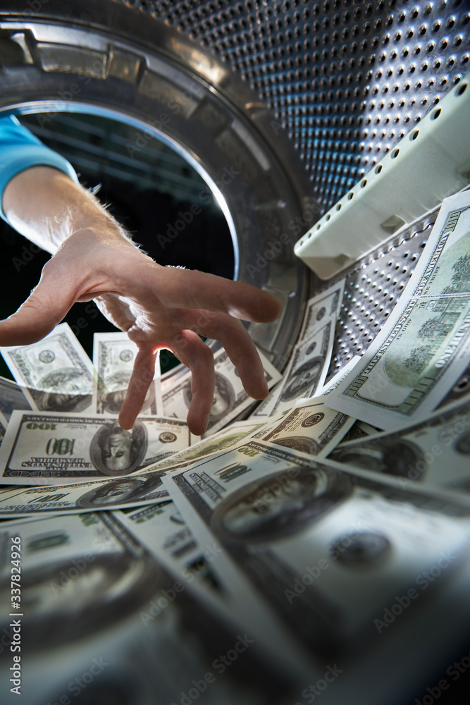 Criminal washing banknotes in machine, money laundering, financial ...