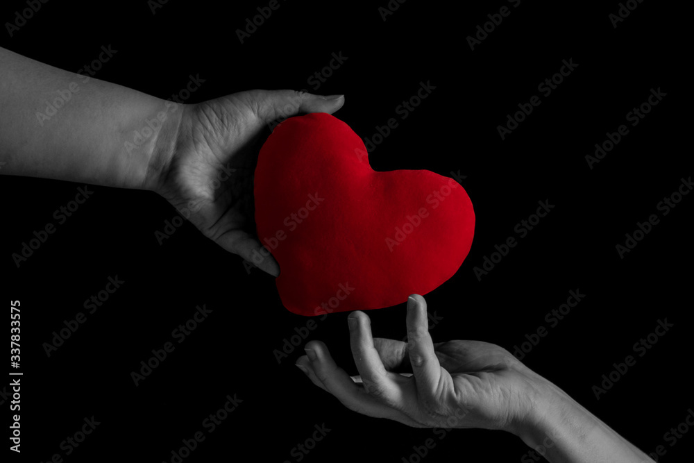 Helping hand concept, Hand giving a Red Heart to another, giving love ...