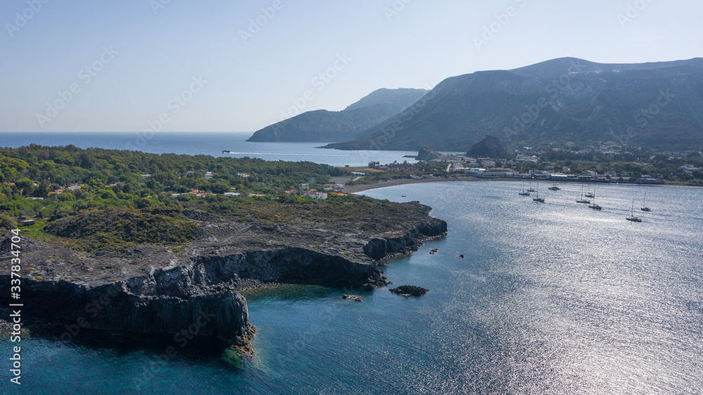 Aerial view photo from flying drone of The black sand beach with yachts ...