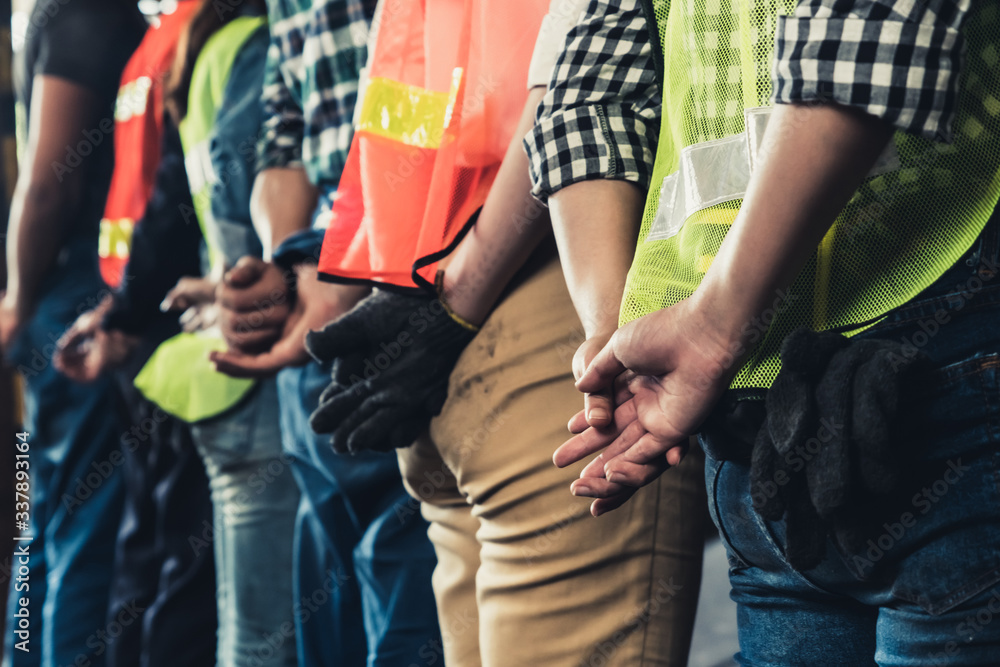 Factory workers standing in a row showing teamwork and unity. Labor and ...