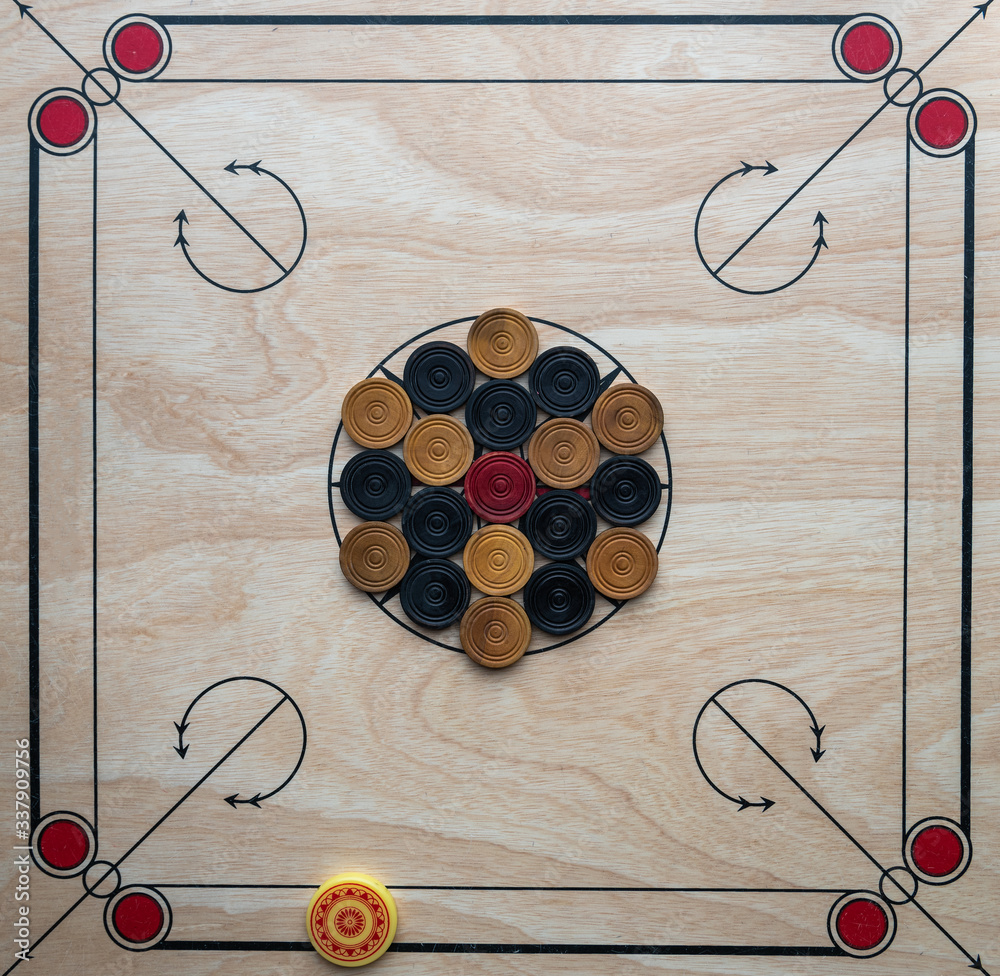 Carrom men and red arranged on the board around the center star. Stock ...