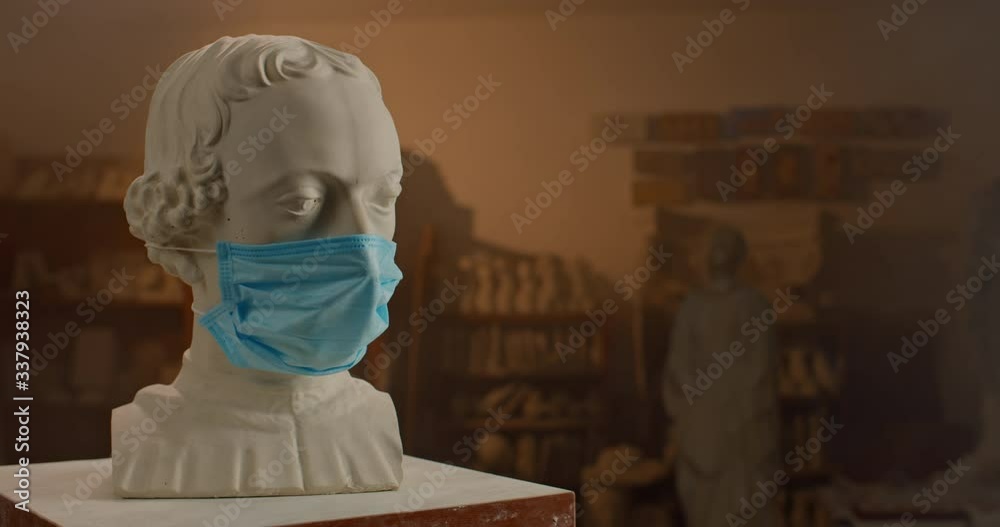 White plaster sculpture head of famous person wearing medical mask ...