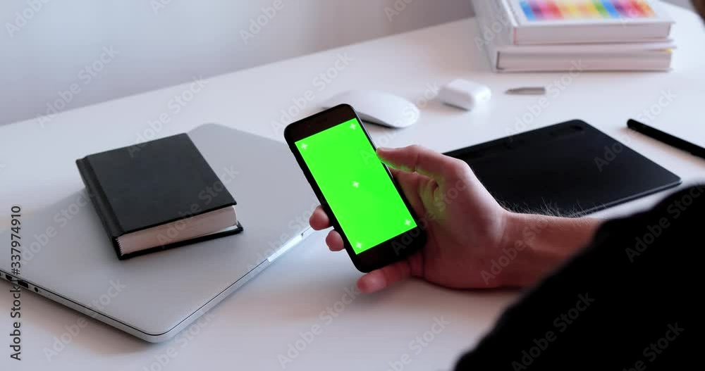 Man using mobile phone chroma key, green screen with markers and display tracking. Hands tapping ...