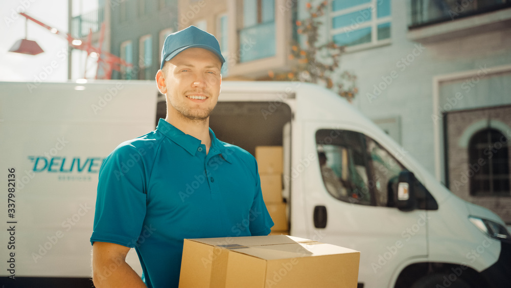 Foto de Portrait of Handsome Delivery Man Holds Cardboard Box Package ...
