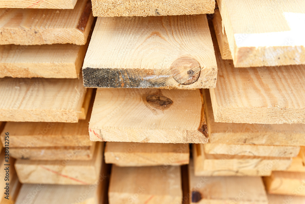 Stack of new wooden studs at the lumber yard. Timber on the ...