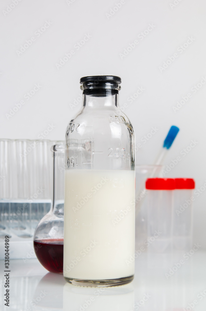 Glassware with white liquids, test-tube and flask for laboratory ...