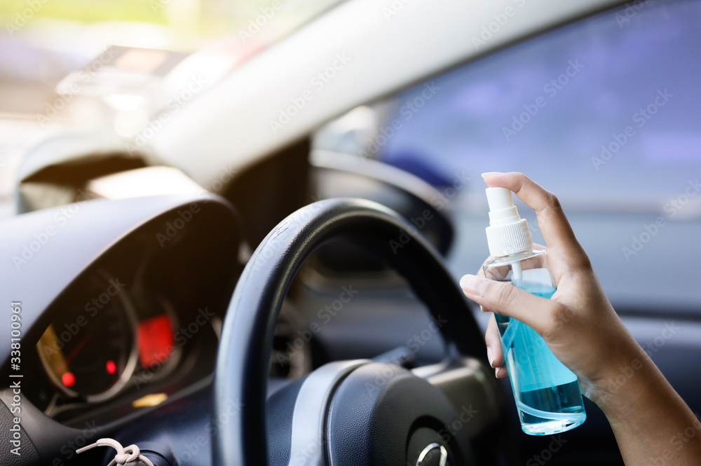 Stockfoto Hand of driver is spraying alcohol,disinfectant spray in car ...