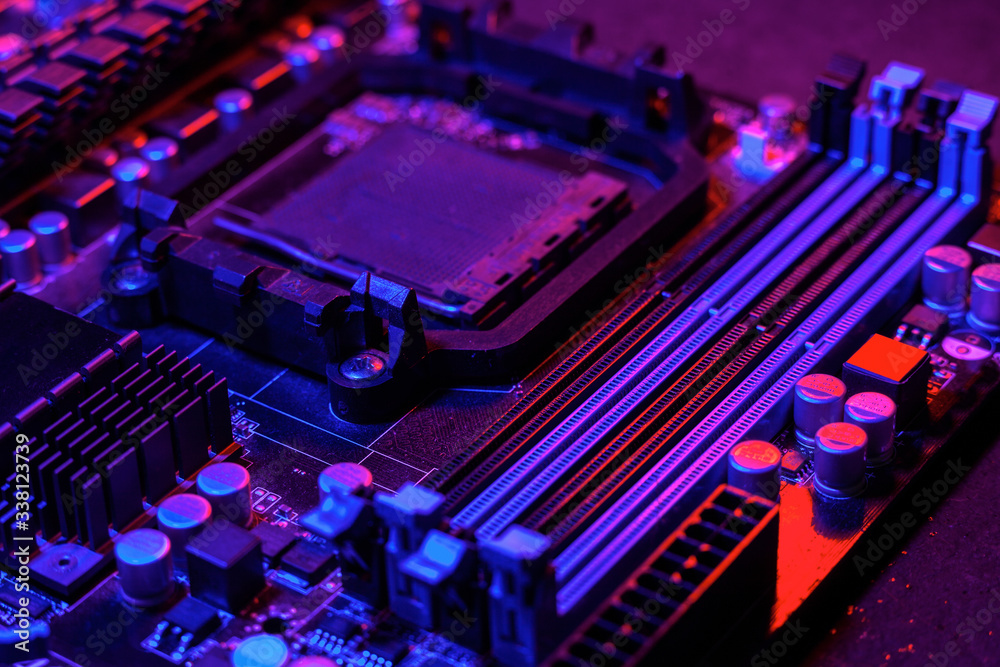 Motherboard in neon red-blue color. Computer parts. RAM and processor ...