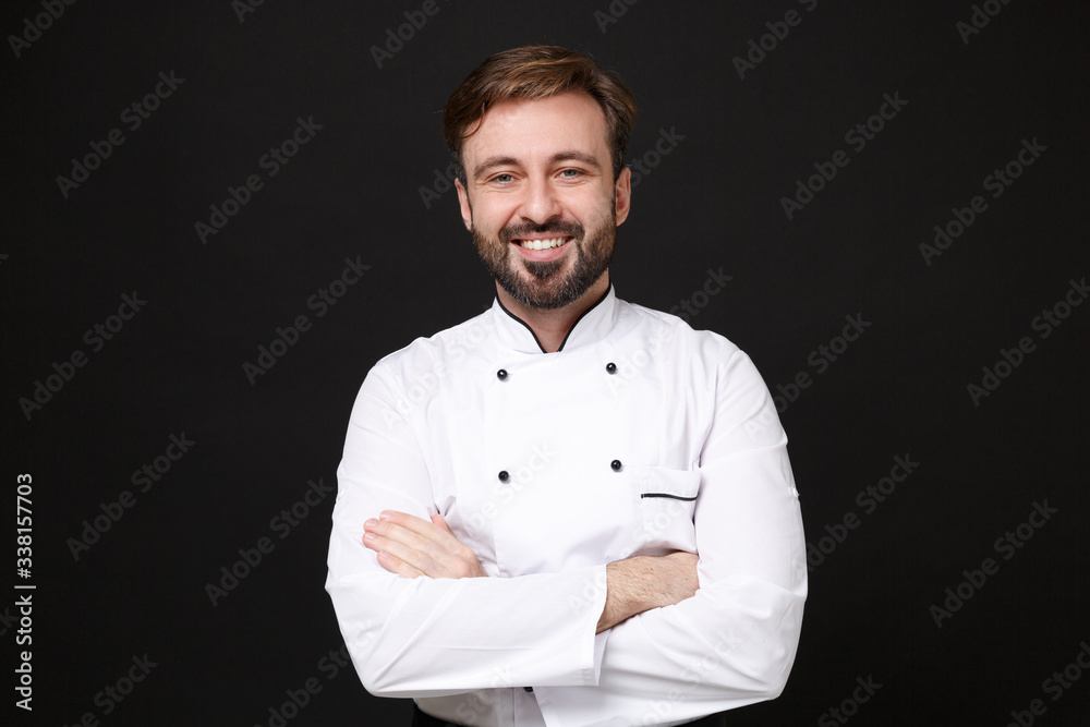 Smiling young bearded male chef cook or baker man in white uniform ...