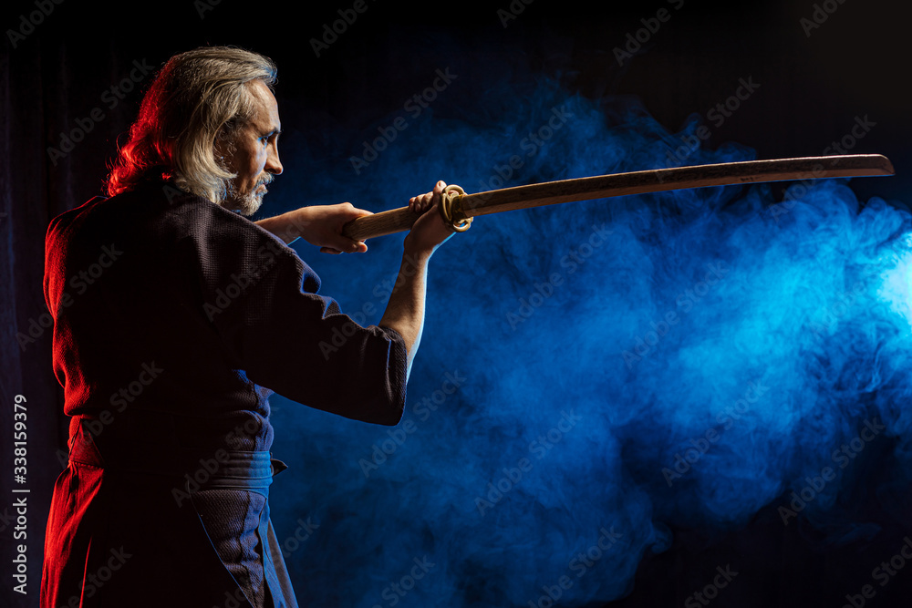side view on serious confident kendo fighter with shinai in hands, man ...