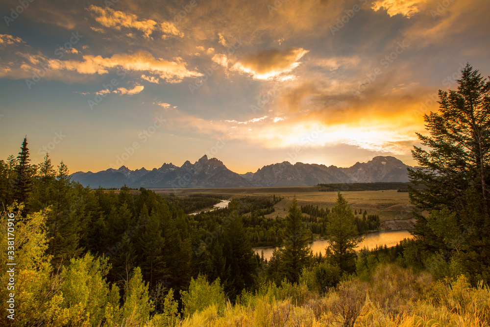 Golden sunlight reflects off the Snake River in Grand Tetons National ...