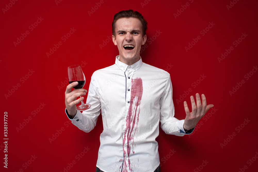 sad guy in a white shirt spilled red wine on himself on a red ...