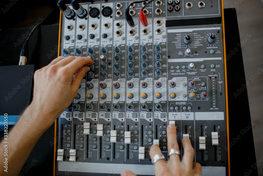Hand on a mixer, operating the leader. Sound engineer working at mixing ...